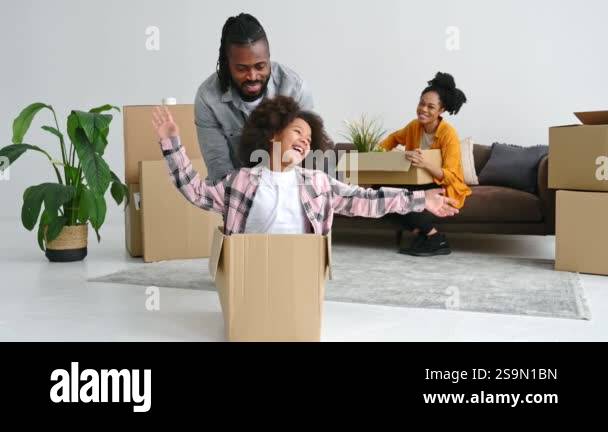 African-American family is having fun while moving to a new home ...