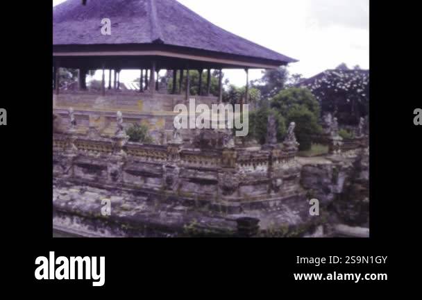Denpasar, bali june 1985: tourists exploring a historic temple complex ...