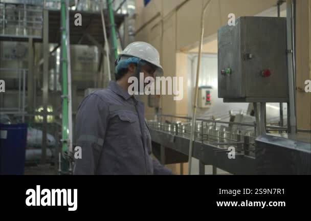 Factory technicians perform routine machinery inspections while the production process is ...