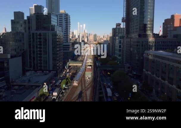 Elevated subway train passing over urban landscape, revealing Long ...