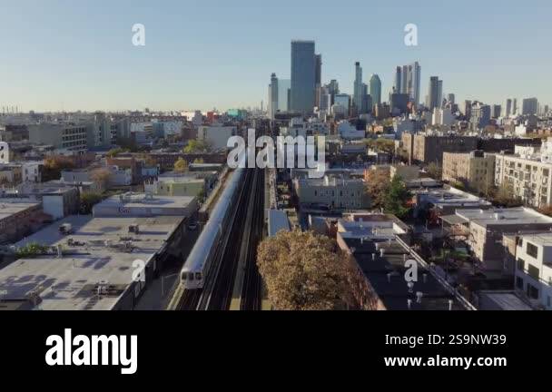Tripod view of an urban elevated subway passing gleaming skyscrapers ...
