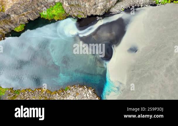 Two rivers meet without mixing in Iceland, clear water and muddy water ...