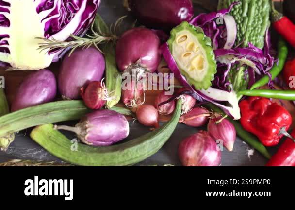 Mixed vegetables featuring purple cabbage, green okra, red shallots ...