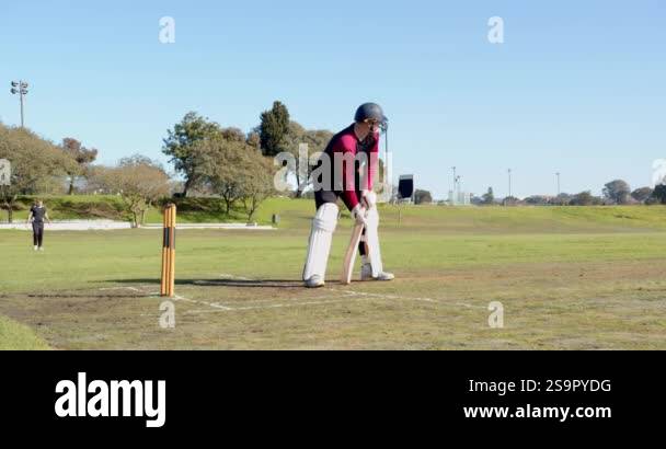 Sprinting on field, cricket player focusing on reaching wicket quickly ...