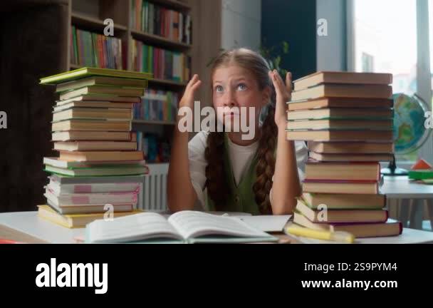 Bored annoyed angry suffering Caucasian little girl school child kid schoolgirl learning hard ...