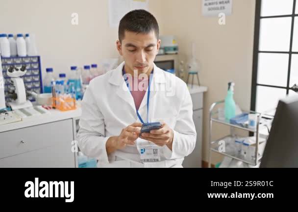 Confident young hispanic scientist in uniform, finger-pointing at you with serious expression ...