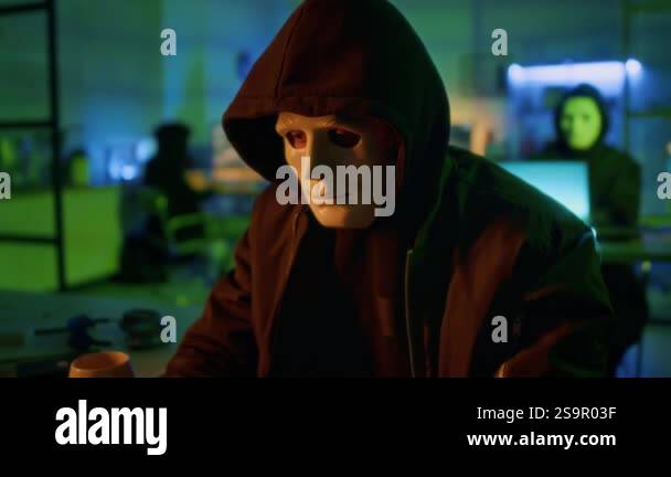 Zoom out view of male cybercriminal dressed in black jacket with face ...