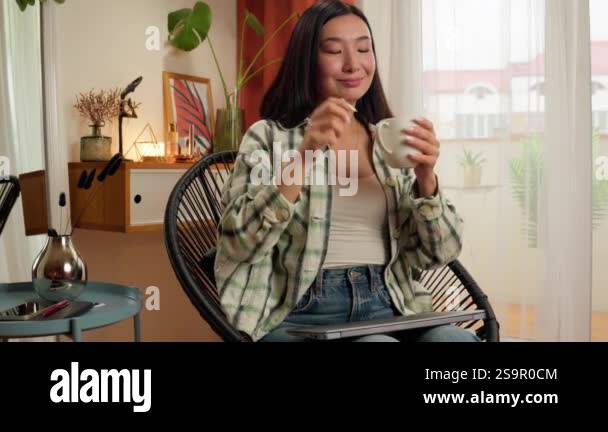 Asian Korean woman drinking tea coffee morning working home stretching ...