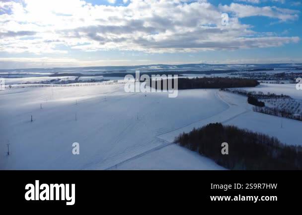 a beautiful winter landscape in a snowy countryside with a cloudy sky ...