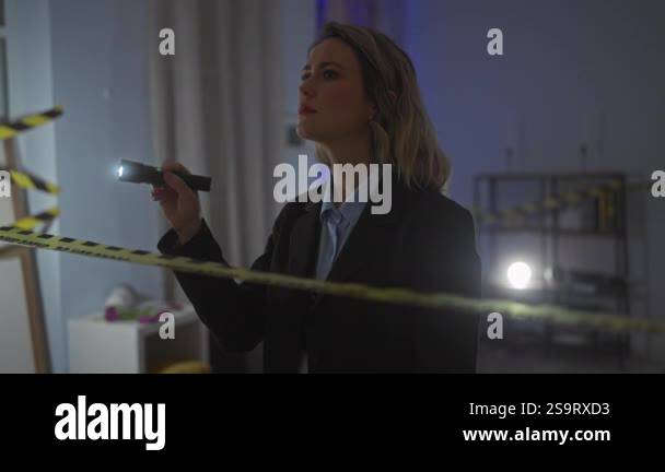 Caucasian investigator woman searching clues with flashlight at indoor ...