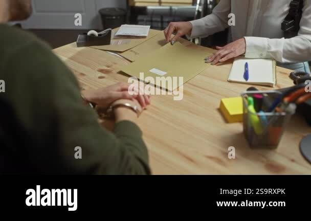A man and woman review documents at an investigation office, implying ...