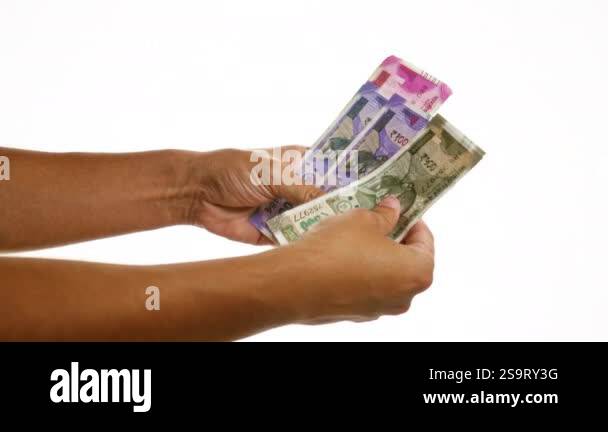 Hand holding indian rupee notes over an isolated white background ...