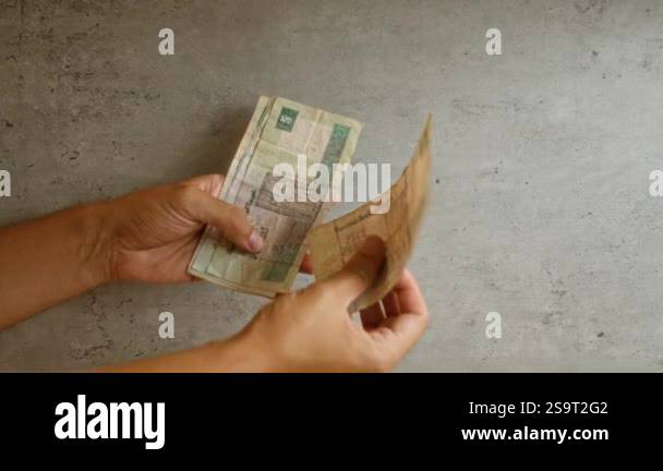 Man holding and fanning egyptian pounds with both hands against a ...