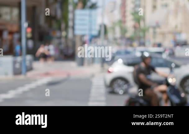 Blurry image depicting an outdoor city street scene with defocused cars ...