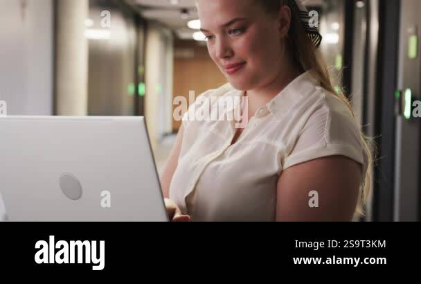 Smiling woman in office wearing white blouse and striped hair bow ...