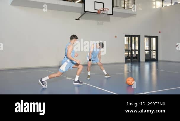 Basketball players stretching on court, preparing for practice session ...