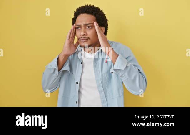 Young african american man, wincing from a fierce migraine, hand on ...