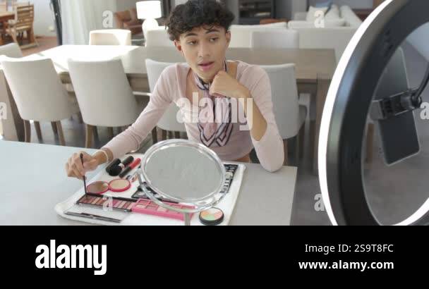 Applying makeup, non binary person using cosmetics and ring light at ...