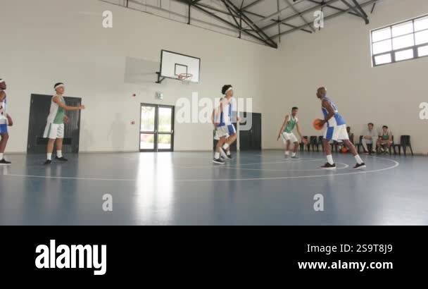Basketball players practicing on indoor court, focusing on teamwork and ...