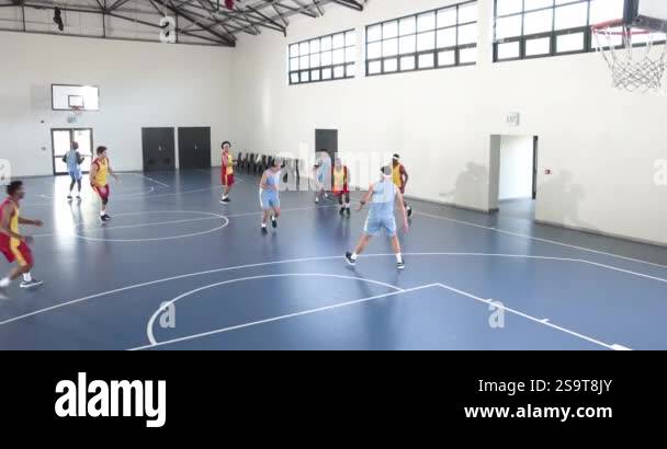 Basketball players in action on indoor court, competing with intensity ...