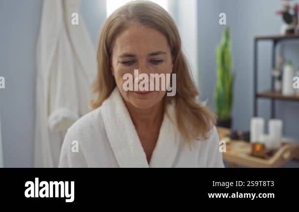 Mature woman relaxing at spa salon wearing white bathrobe indoors Stock ...