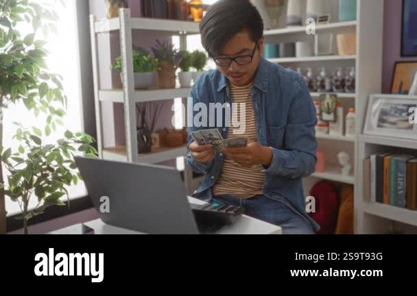 Young man sorting money while working indoors in a decor shop with ...