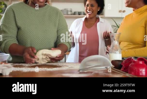 Friends cooking meal together, sharing laughter in cozy kitchen setting ...