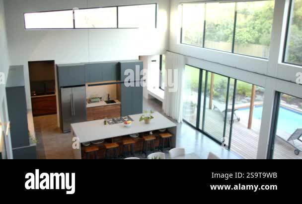 Modern home with large windows overlooking pool and garden, bright and ...