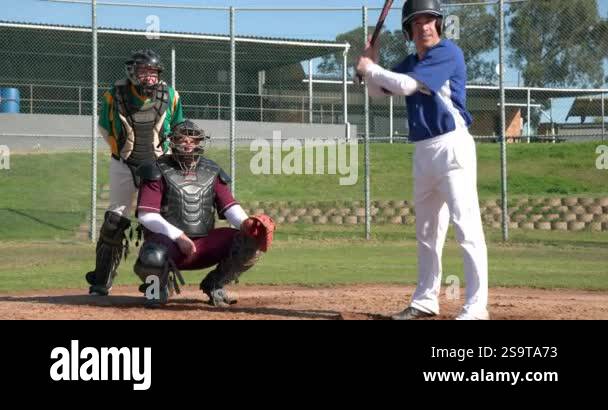 Playing baseball, batter in blue uniform preparing to hit with catcher ...