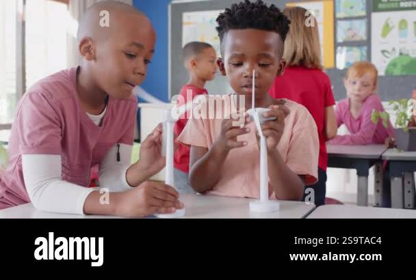 In school, children collaborating on science project with plants in ...