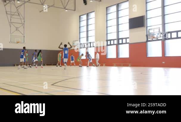 Playing basketball in school gym, students practicing game on indoor ...
