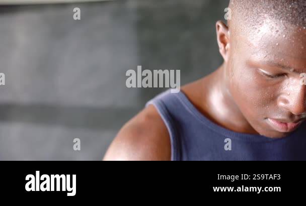 Sweating and focusing, african american man in tank top exercising ...