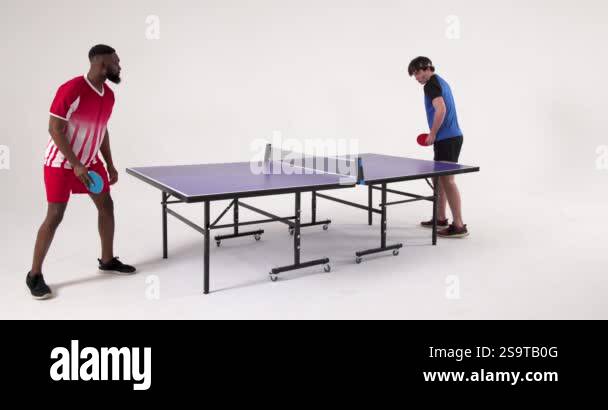 Playing table tennis, two men competing in friendly match indoors ...