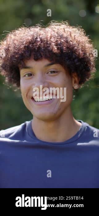 Vertical video: Smiling young man enjoying sunny day outdoors, feeling ...