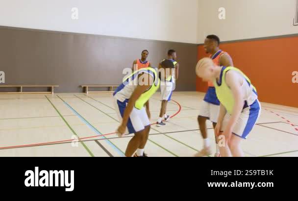 In school gymnasium, basketball players practicing teamwork and ...