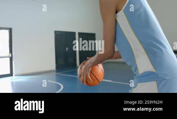 Playing basketball, woman in sportswear aiming to shoot ball at hoop ...