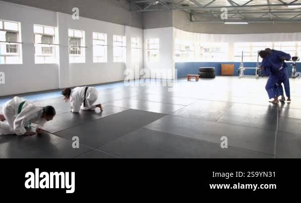 Practicing judo, two athletes sparring in dojo, wearing traditional ...