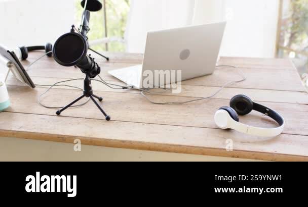 Podcast setup with laptop, microphone, and headphones on wooden desk at ...