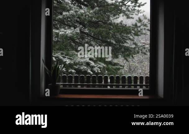 Atmospheric winter footage. Snowfall outside the window of a country ...