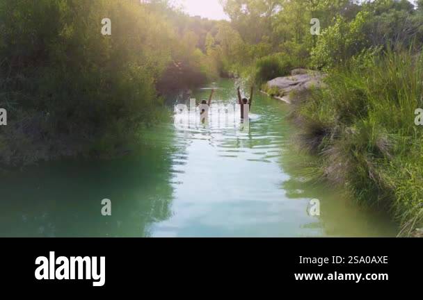 Aerial view of a couple friends swimming together in a river in summer ...