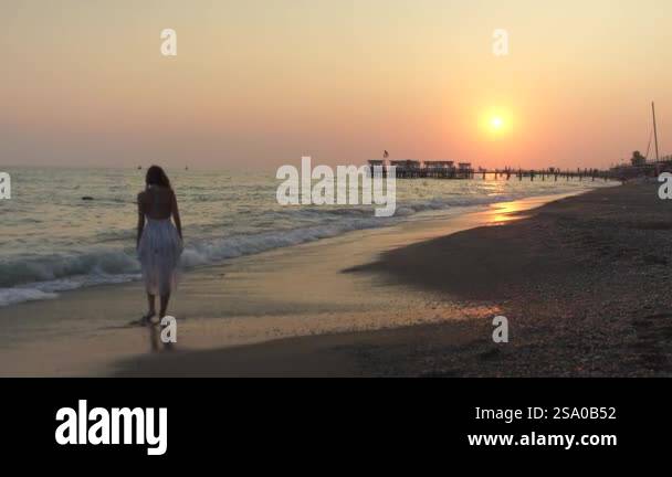A joyful moment as a girl is splashed by a sea wave, her face glowing ...
