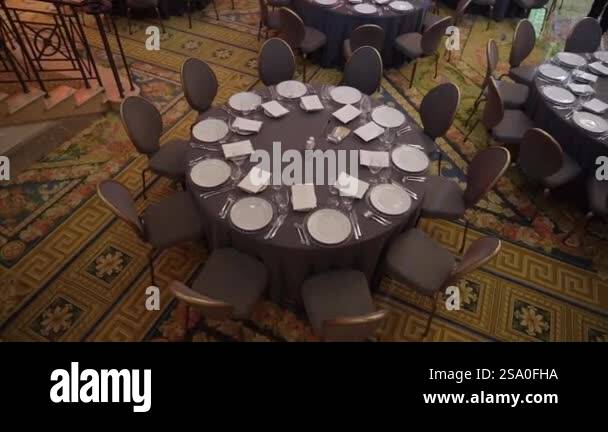 A luxurious display featuring round banquet tables adorned with plates ...