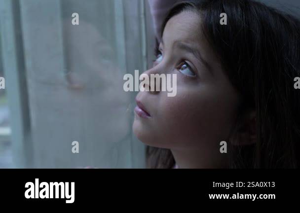 Sad pensive child leaning on glass window looking outside feeling ...