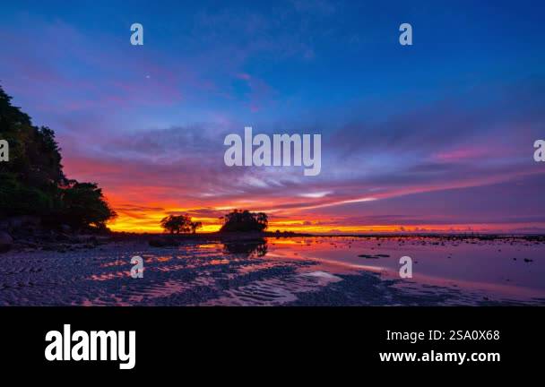 A breathtaking view of a vivid orange and purple sunset reflecting on ...