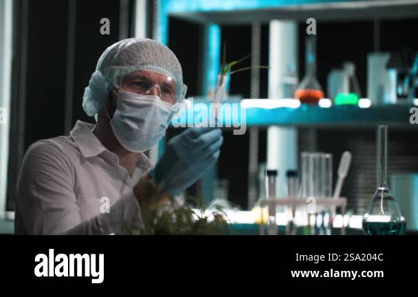 male laboratory assistant in protective glasses in sterile suit using ...
