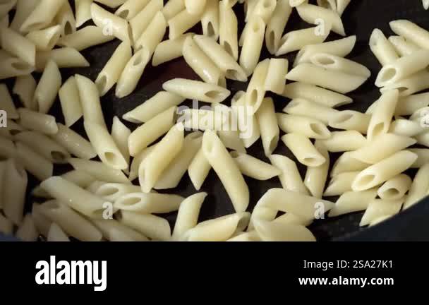 Boiled penne pasta during roasting on frying pan, top view Stock Video ...