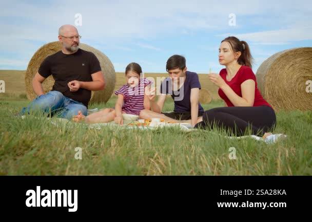 Happy family having picnic near hay bales outdoors. Father mother son ...