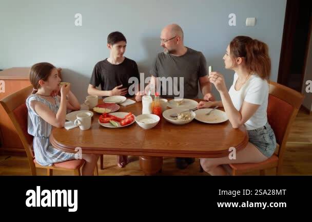 Happy family sharing conversation during lunchtime. Father mother ...