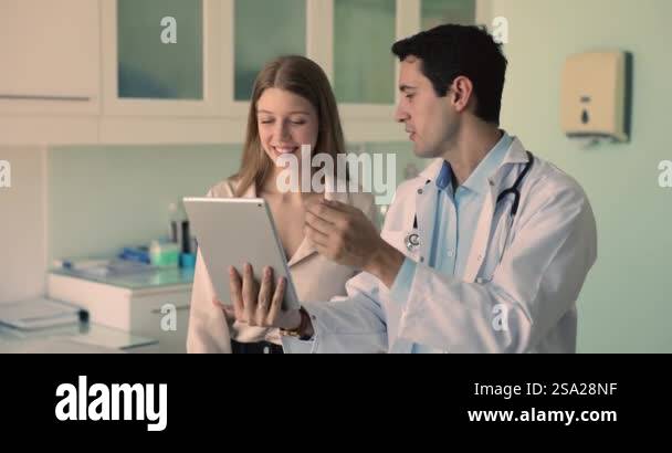 Positive male doctor and female patient watching electronic content on ...