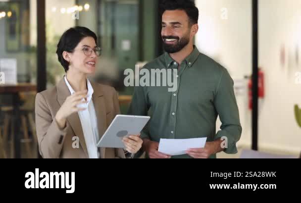 Two attractive smiling colleagues lead discussion met in coworking ...